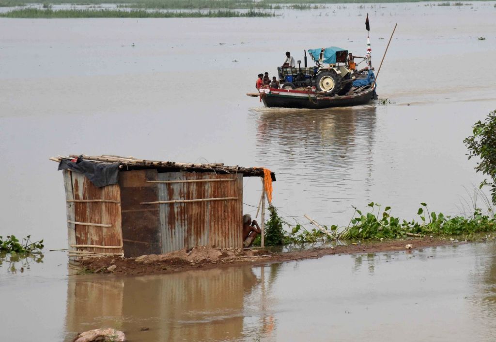 A boat carrying people wade through a flood affected area