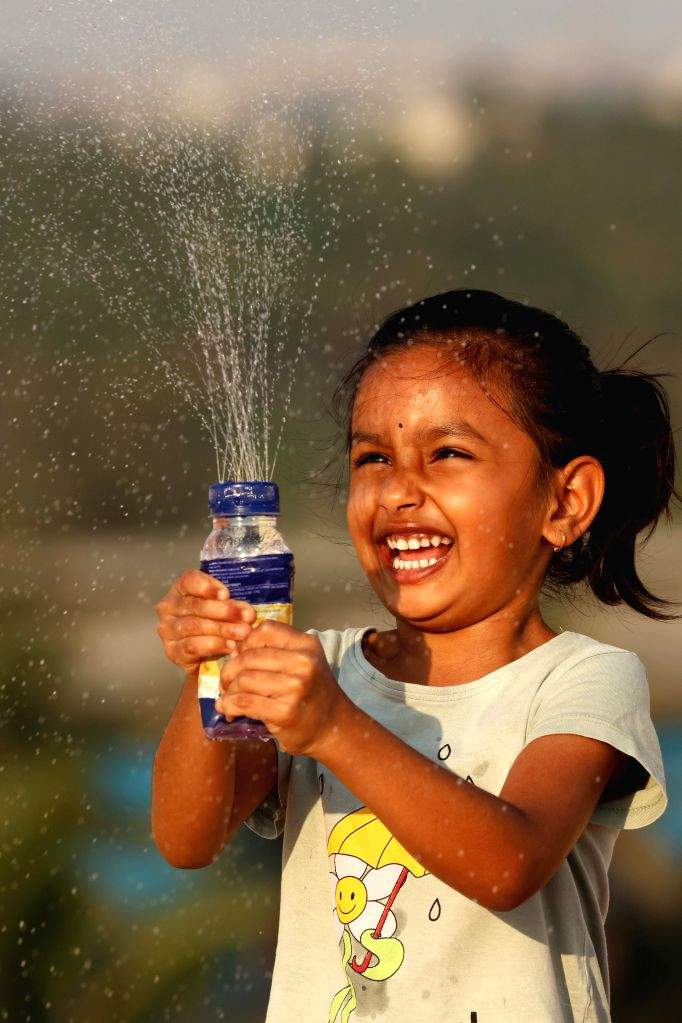 A child joyfully plays with water to beat the summer heat