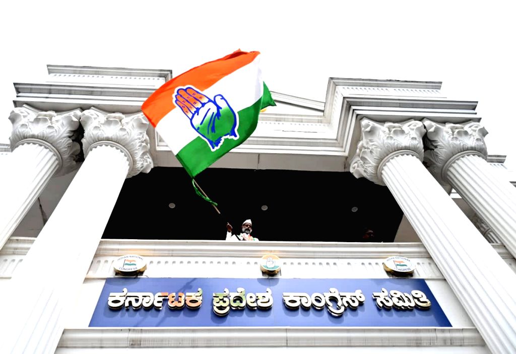 Bengaluru : A congress worker waves the party flag as he celebrates ...