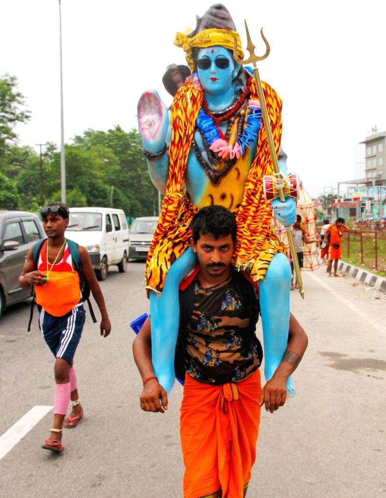 A devotee of Lord Shiva (Kanwariya) carrying the idol on his shoulders ...