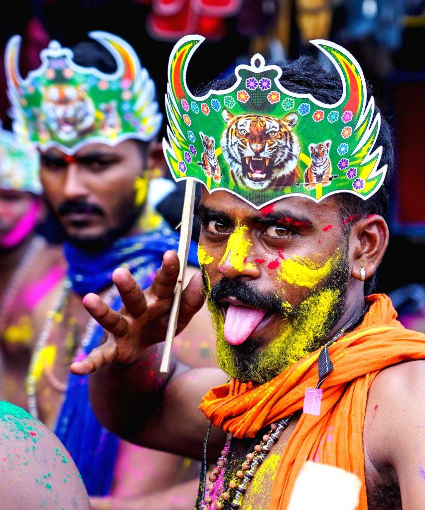 A devotee poses for a photo as he performs the Pettathullal ...