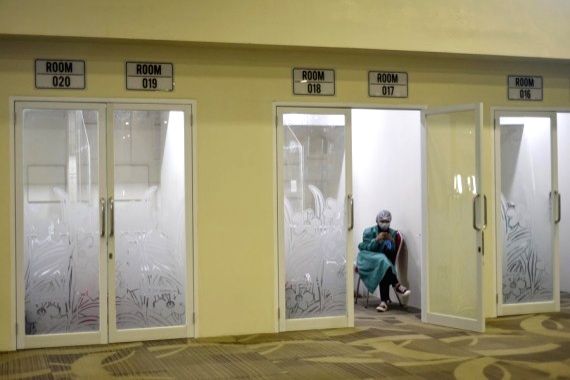 : A health worker is seen waiting at a swab test room at Ngurah Rai ...