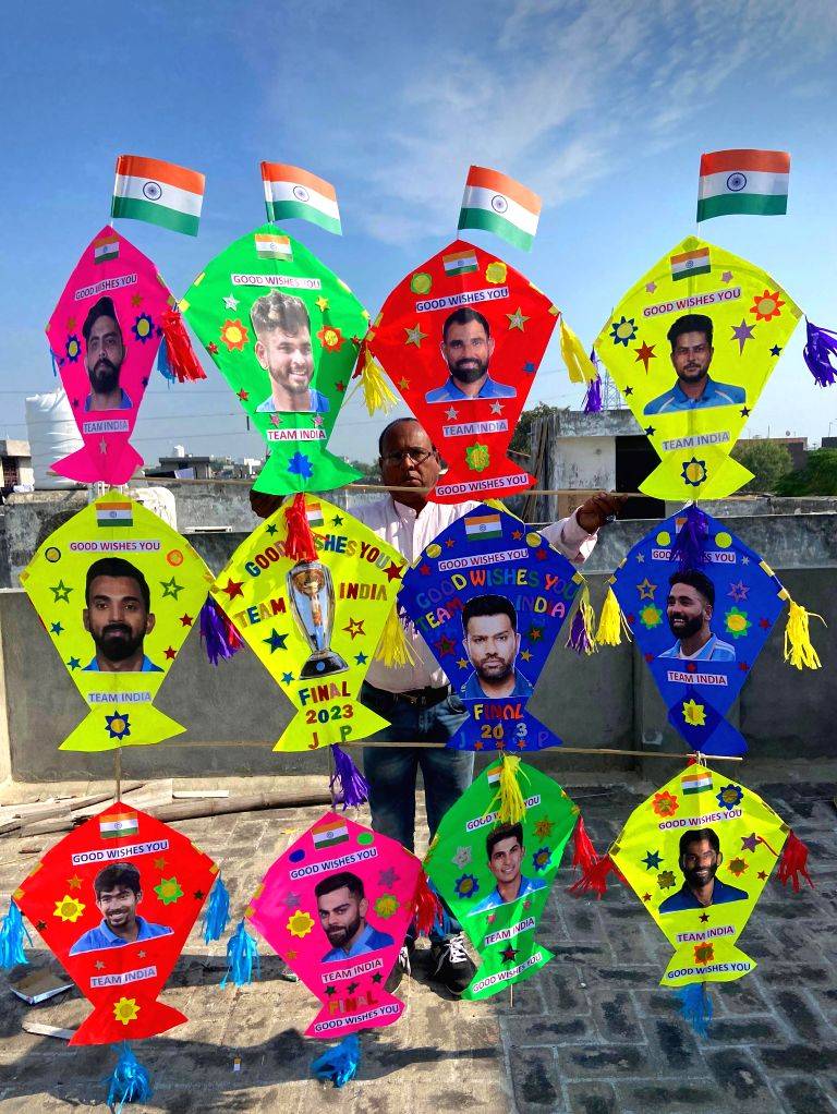 A kitemaker displays kites decorated with pictures of Indian cricketers ...