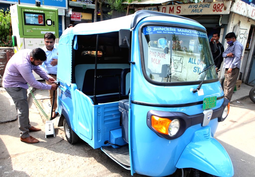 A man charges a battery of an e-auto rickshaw from Plastic Reverse ...
