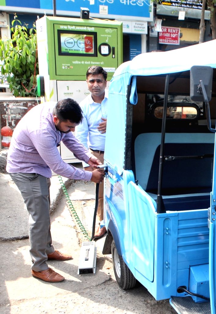 A man charges a battery of an e-auto rickshaw from Plastic Reverse ...