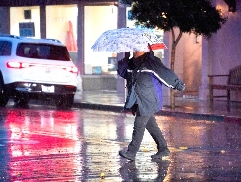 A pedestrian walks in storm in Millbrae, California, the United States ...