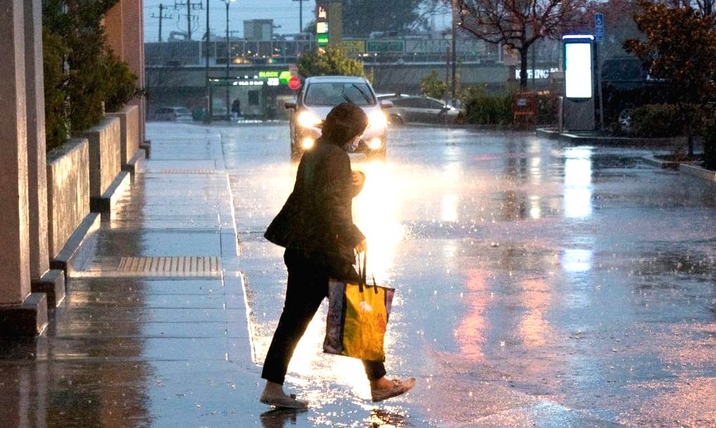 A pedestrian walks in storm in Millbrae, California, the United States ...