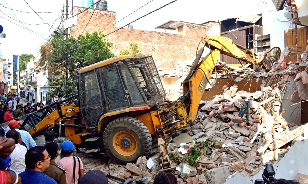 A Prayagraj Development Authority bulldozer demolishes properties of ...
