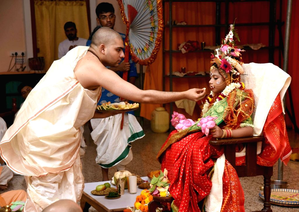 A priest performs rituals to a girl child during 'Kumari Puja