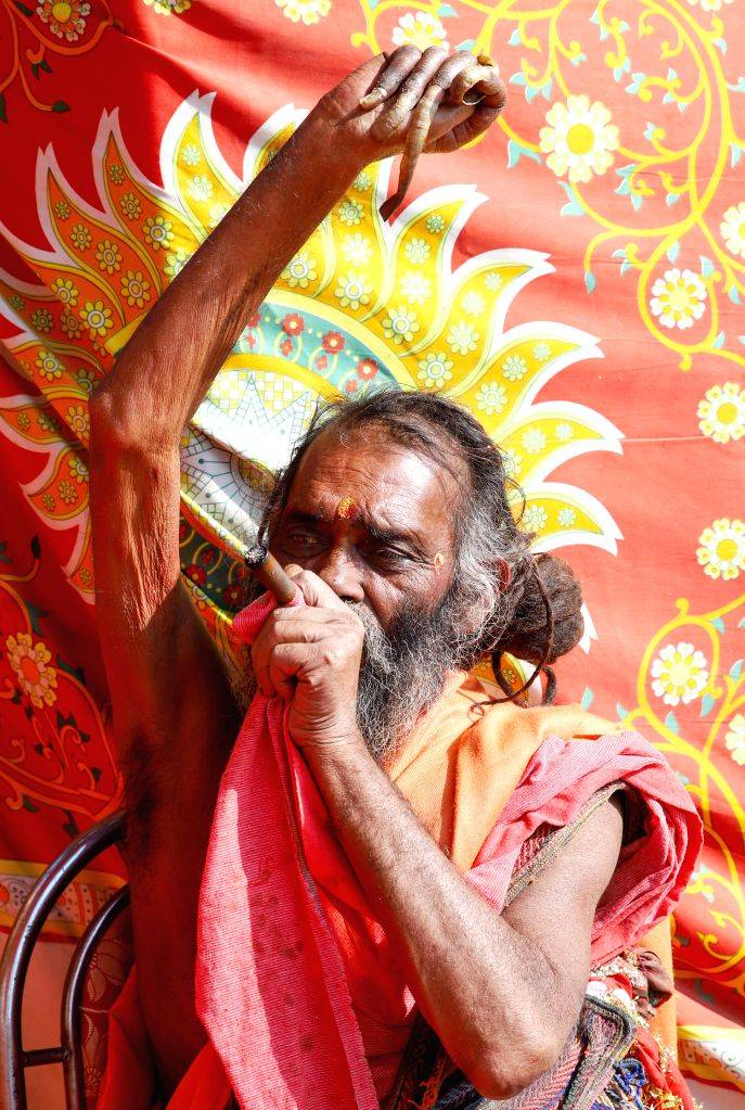 A Sadhu, or Hindu holy man, raises his hand with long nails as he ...