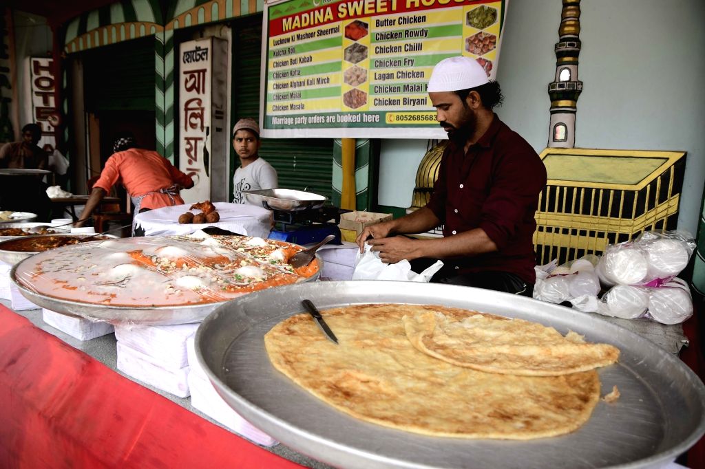 A shopkeeper sells giant Paratha (bread) with Halwa (sweet)