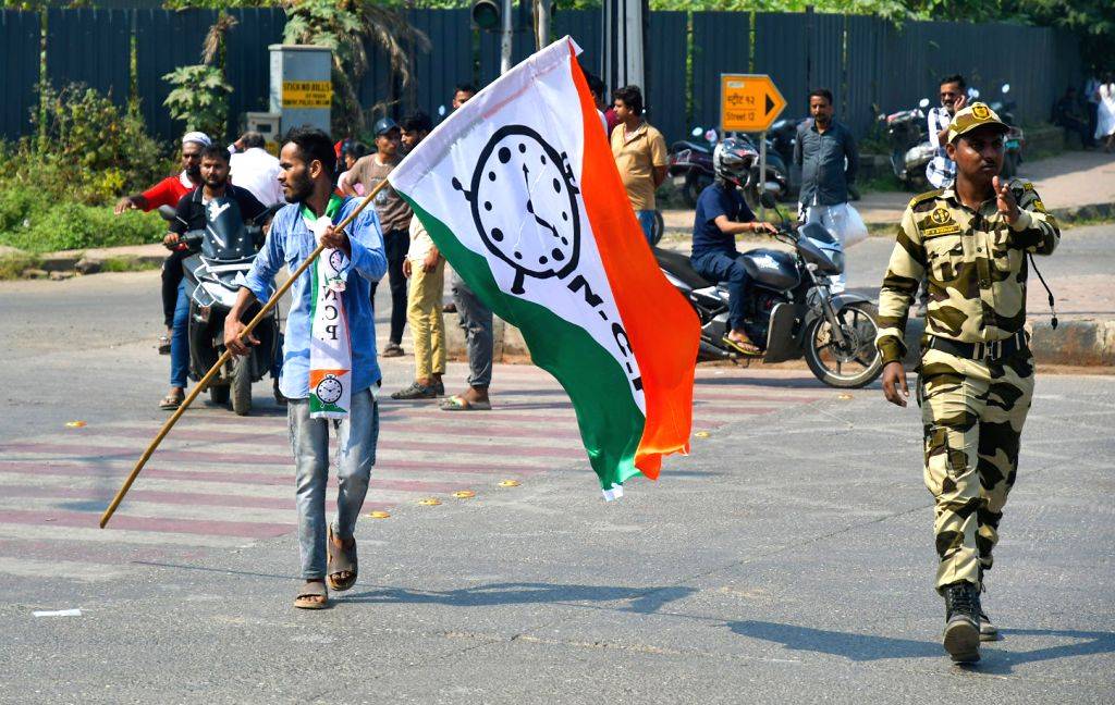 A supporter holding a Nationalist Congress Party (NCP) flag