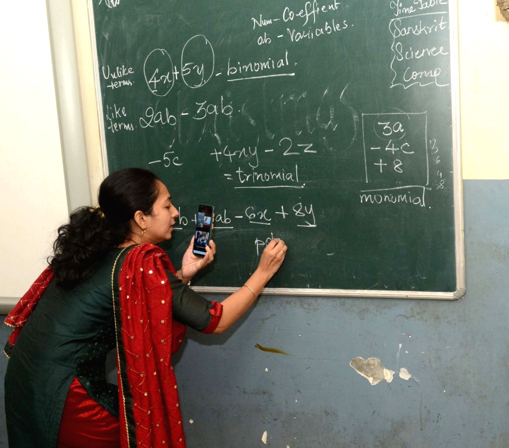 A teacher working at a government school takes online class inside an ...