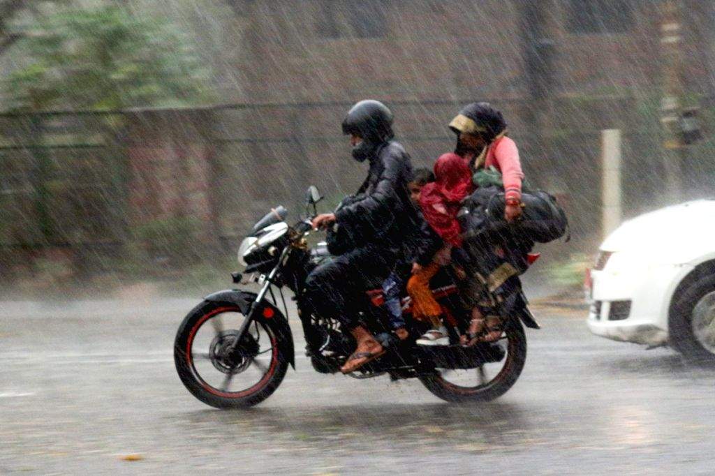 A two-wheeler plies on the road amid rain in