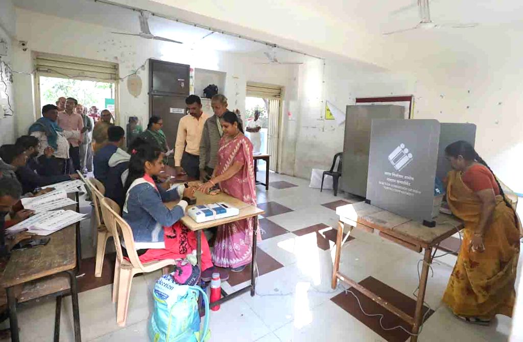 A voter casts her vote inside a polling booth