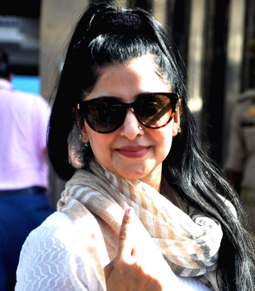 A voter shows her finger marked with indelible ink after casting her ...
