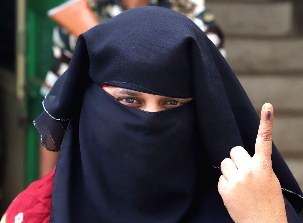 A voter shows her finger marked with indelible ink after casting her ...