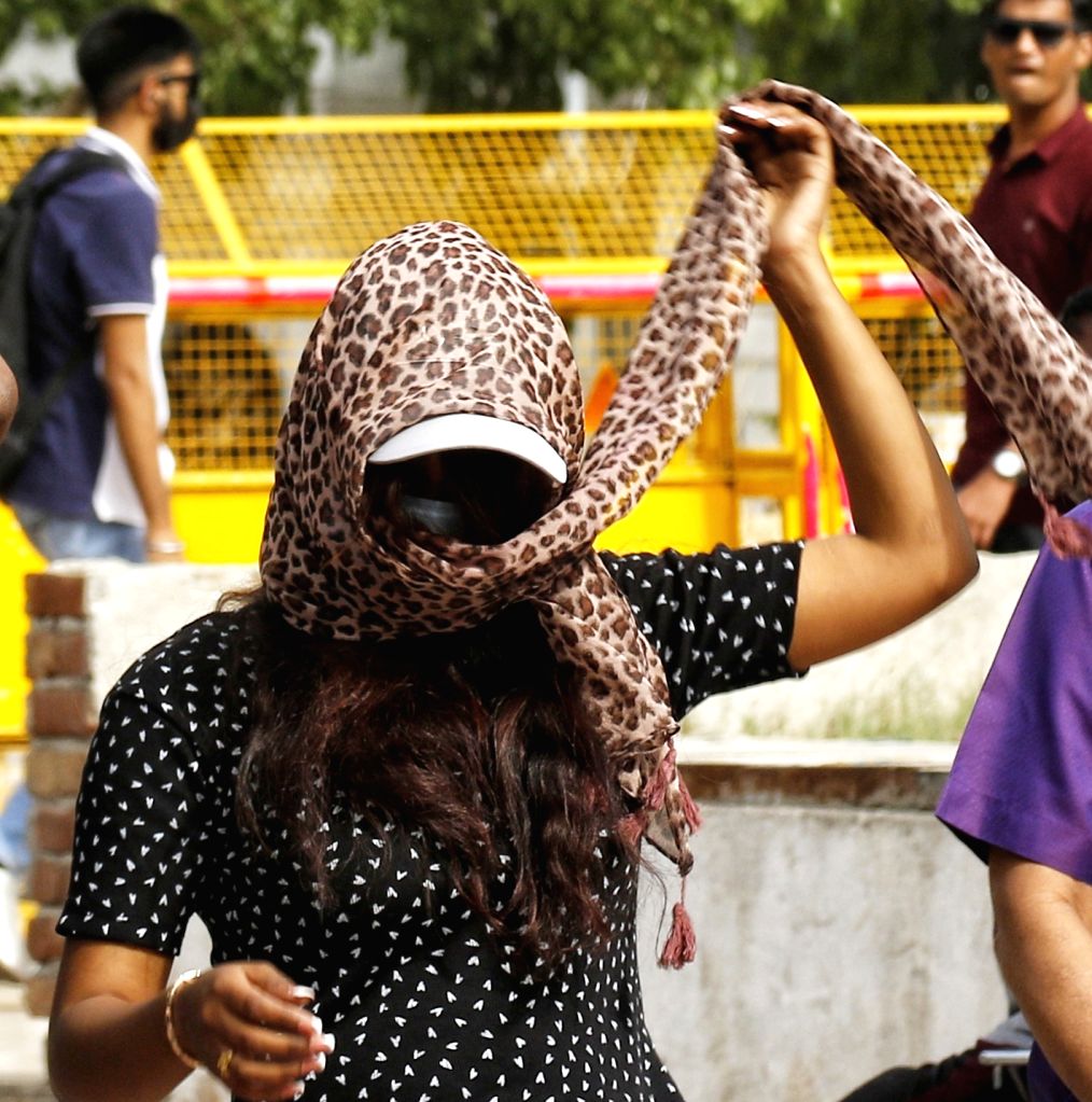 A woman covering her face with a piece of cloth tries to protect from ...