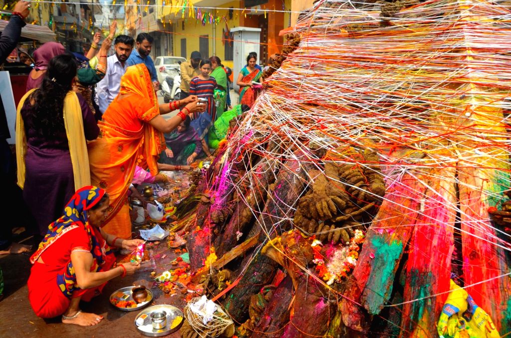 A woman performs a ritual during 'Holi Poojan
