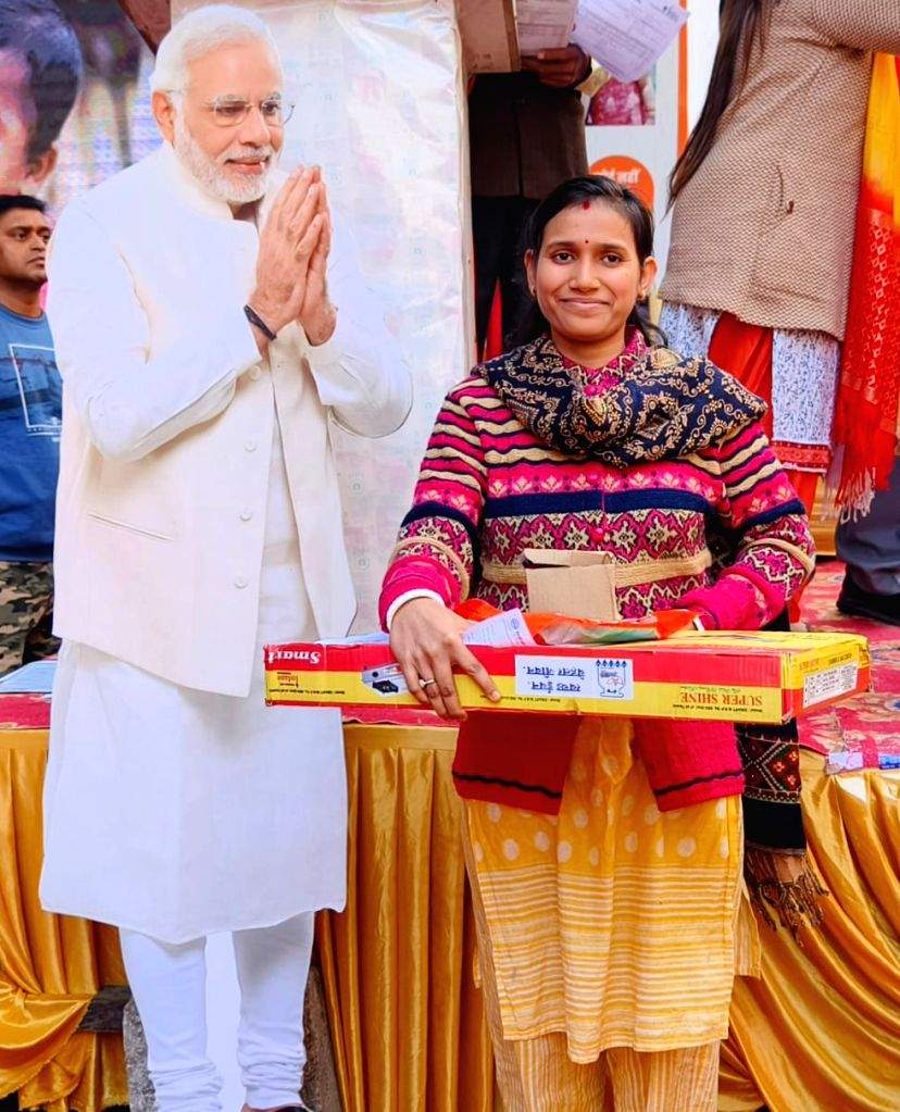 A woman poses for a photo with a cutout of PM Narendra Modi at a selfie ...
