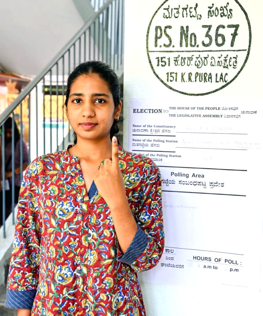 A woman voter shows her inked finger after casting her vote for the ...