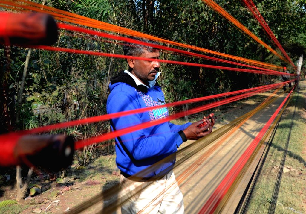 A worker prepares coloured kite threads along the roadside ahead of the ...