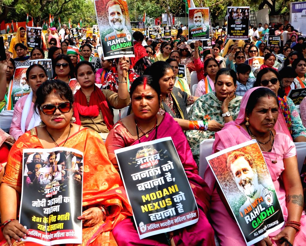 All India Mahila Congress workers hold placards staging a protest