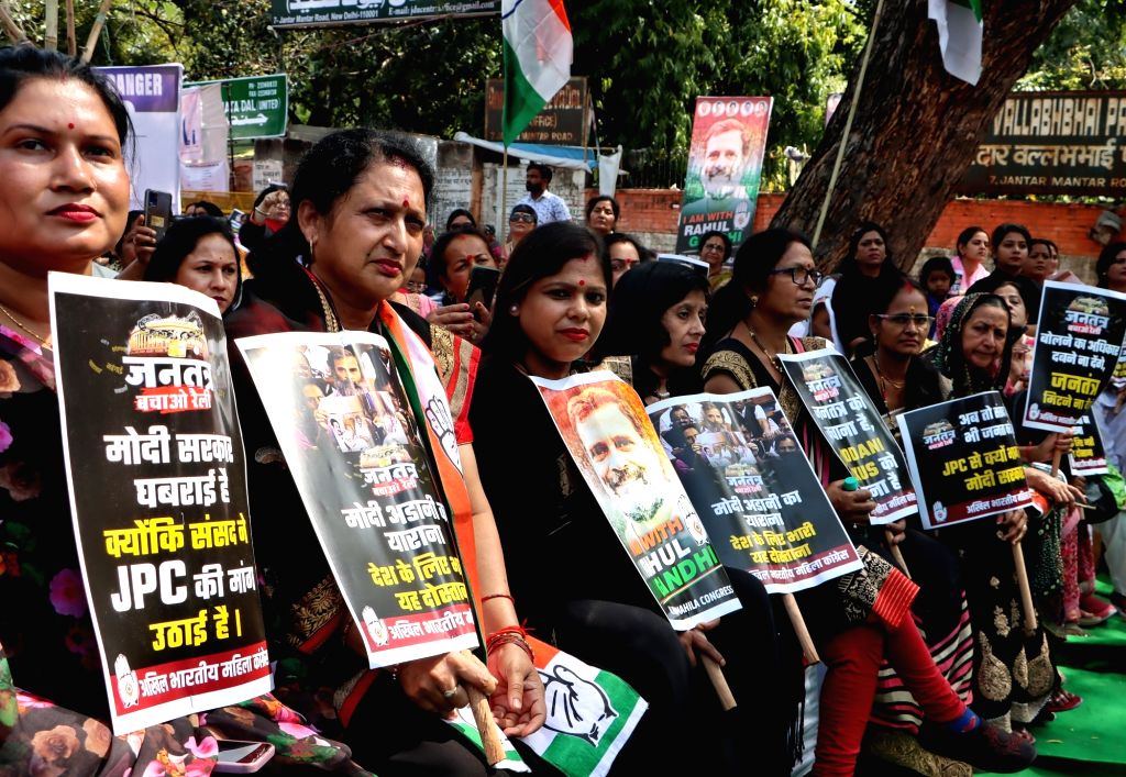 All India Mahila Congress workers hold placards staging a protest