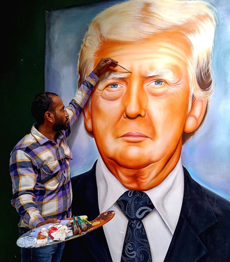 An artist gives final touches to a painting of US President-elect ...