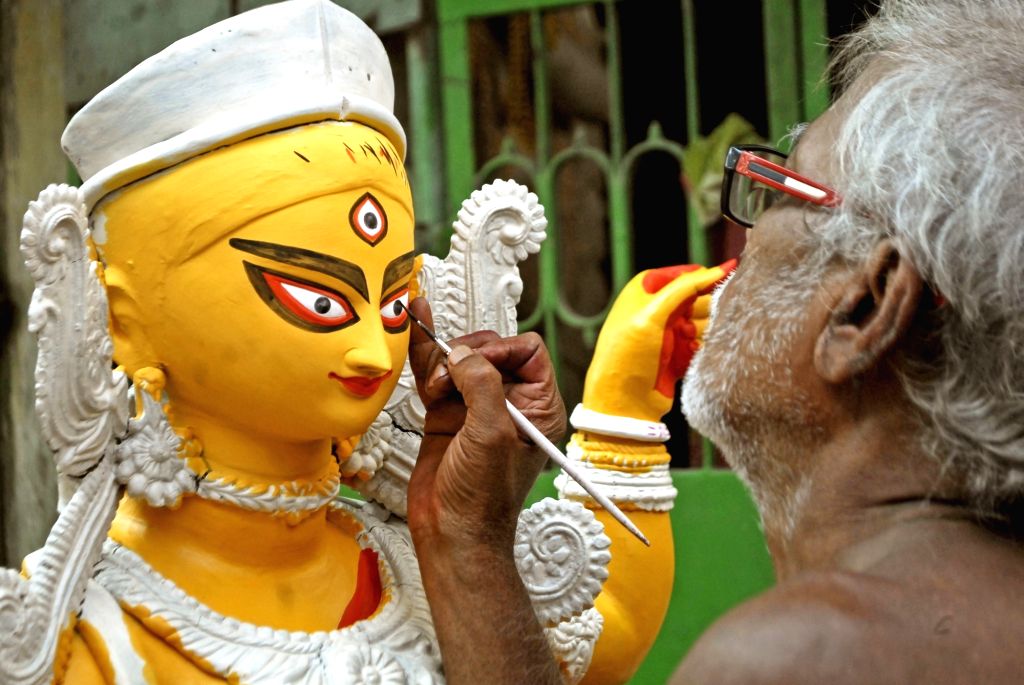 An artist gives finishing touches to an idol of Goddess Jagaddhatri at ...