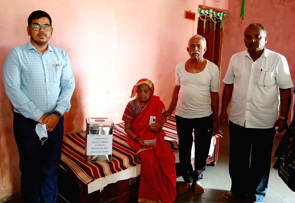 An elderly voter shows her identification card during voting for the ...