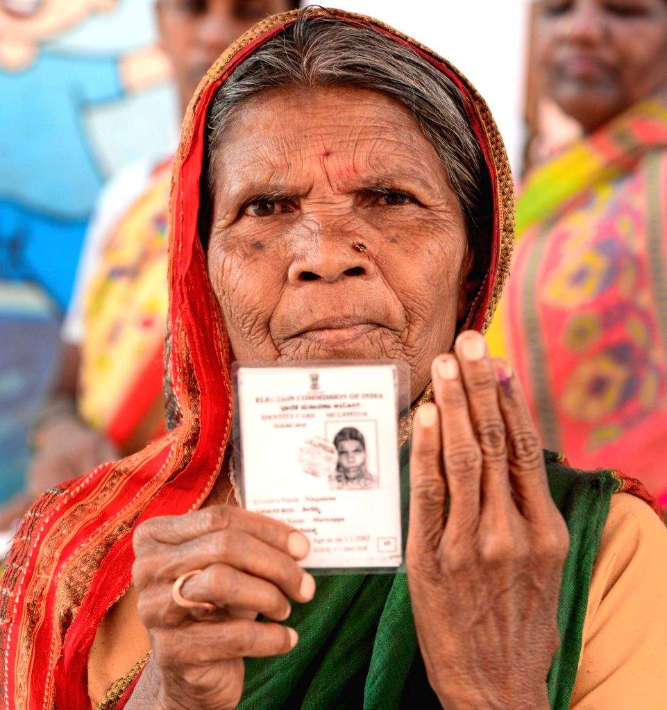 An elderly woman shows her inked marked finger after casting her vote ...