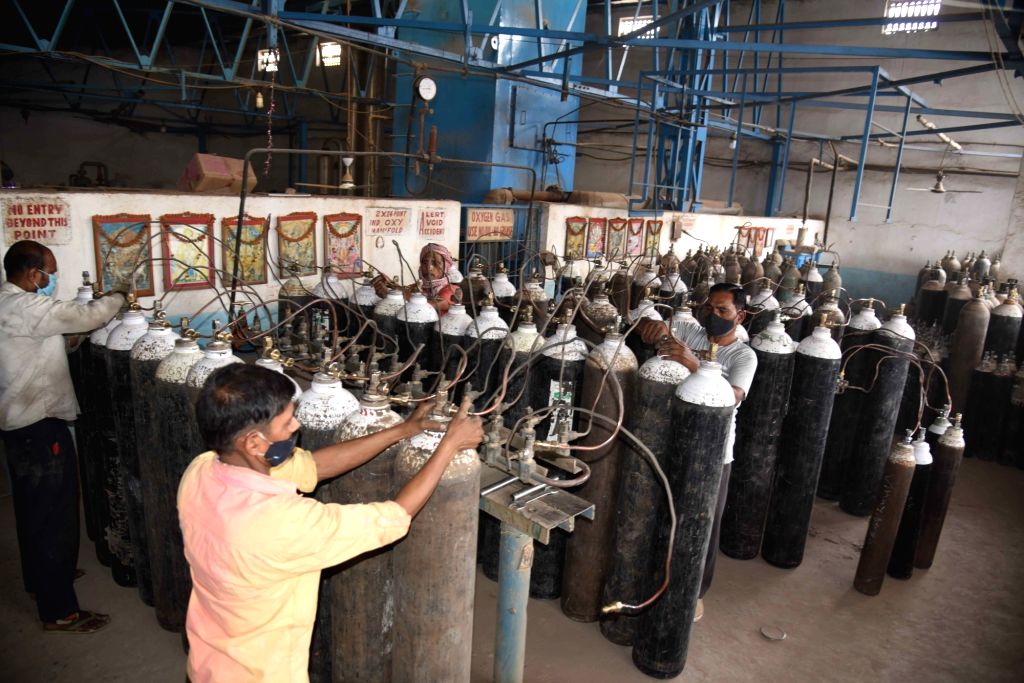An employee refilling cylinders at an oxygen plant