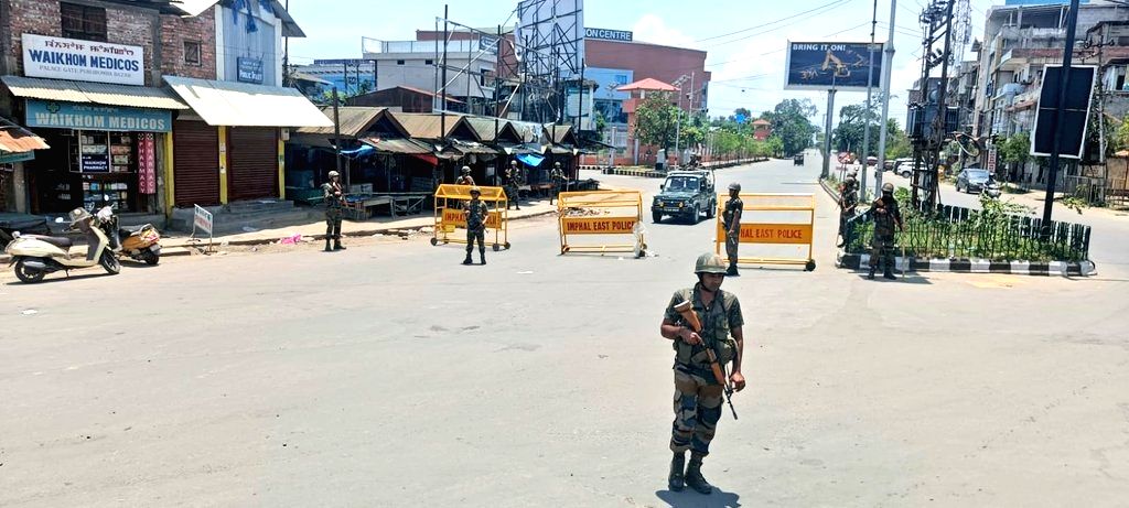 Army personnel stand guard at a checkpoint in Imphal
