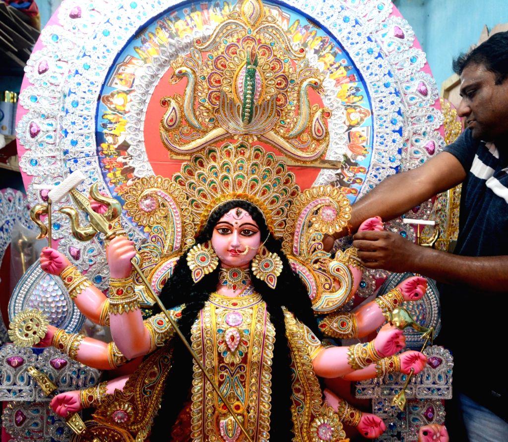 Artist Koushik Ghosh gives finishing touches to an idol of Goddess Durga