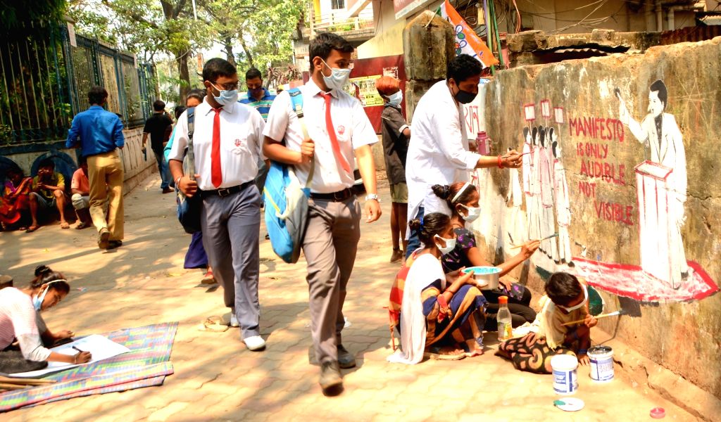 Artist Suman Mitra along with street children drawing a wall graffiti