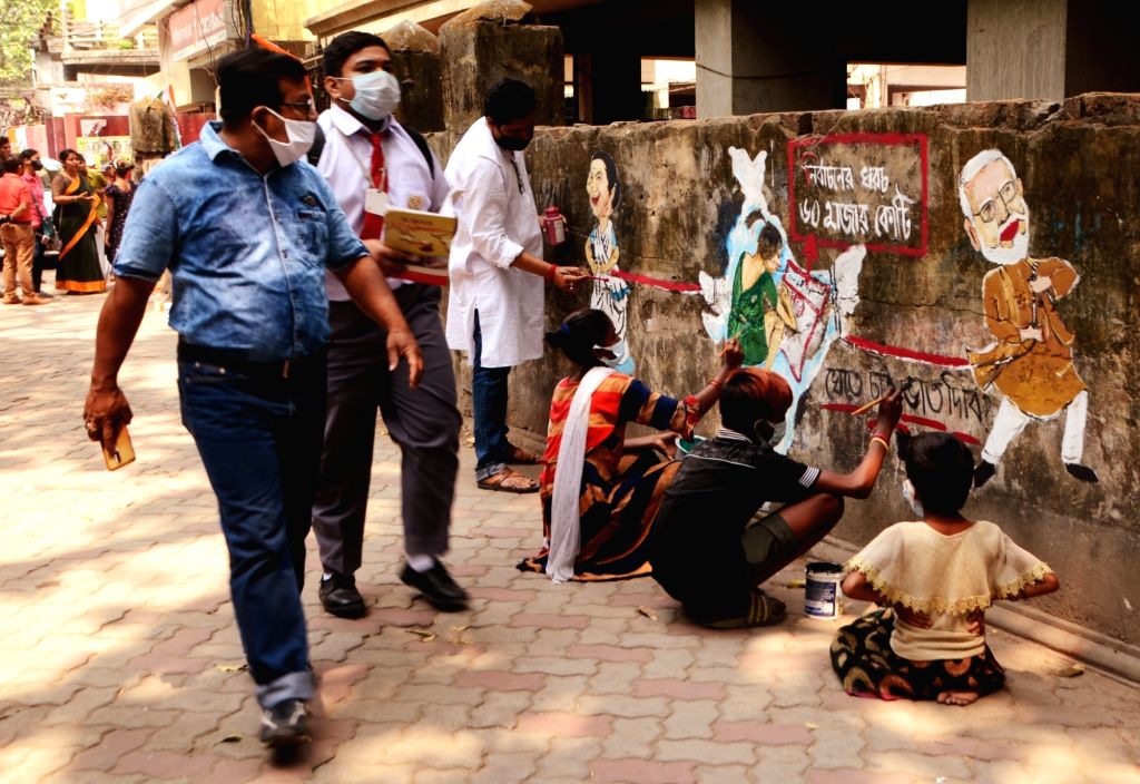 Artist Suman Mitra along with street children drawing a wall graffiti