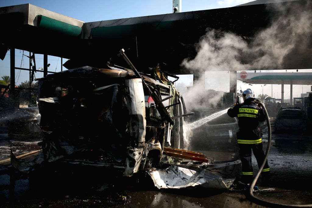 Israeli firefighters extinguish a fire that broke out after a rocket ...
