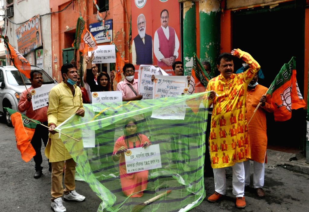 : Kolkata :BJP Activists protest with a mosquito net over malaria and ...