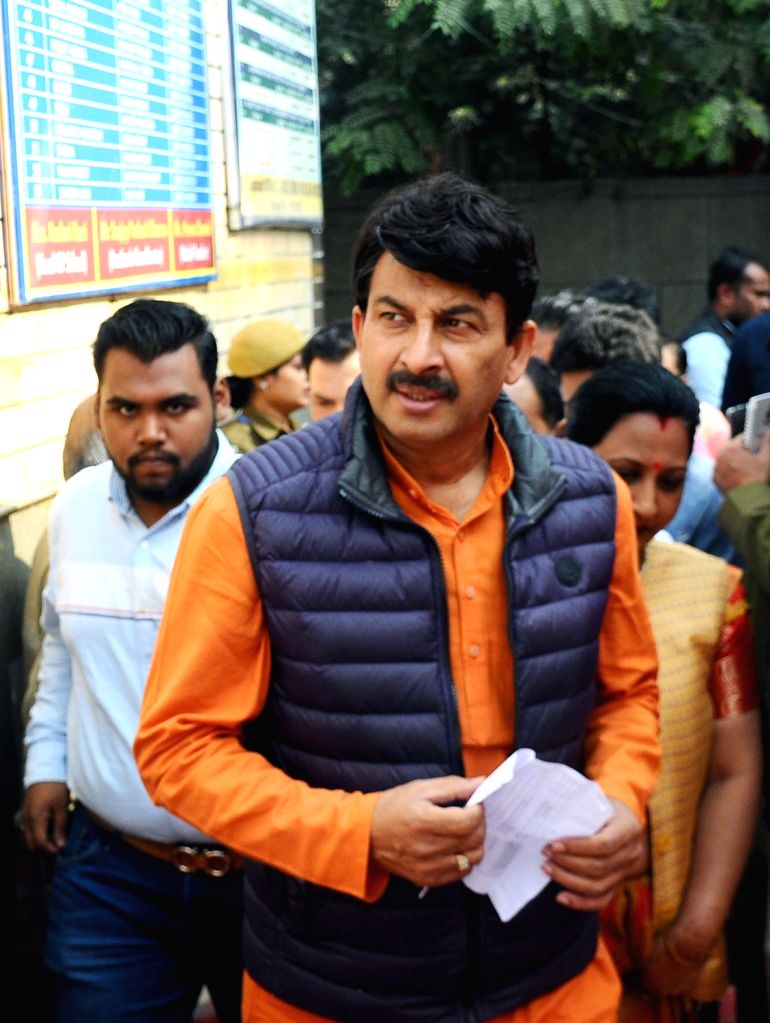 BJP MP Manoj Tiwari stands in a queue to cast a vote
