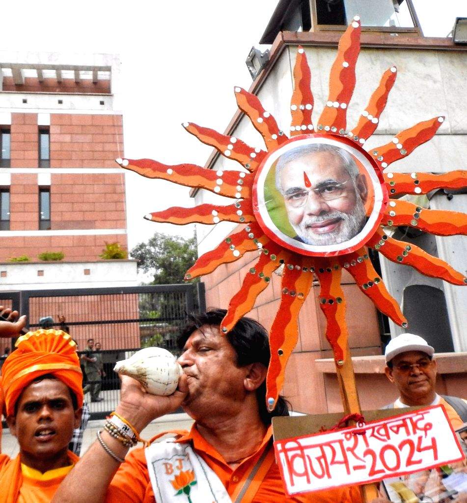 BJP workers celebrate the party's lead during the counting of votes for ...
