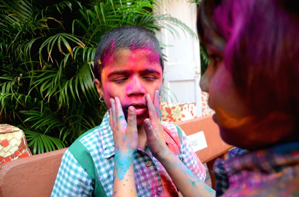 Blind students play with colors at their school on the eve of Holi in ...
