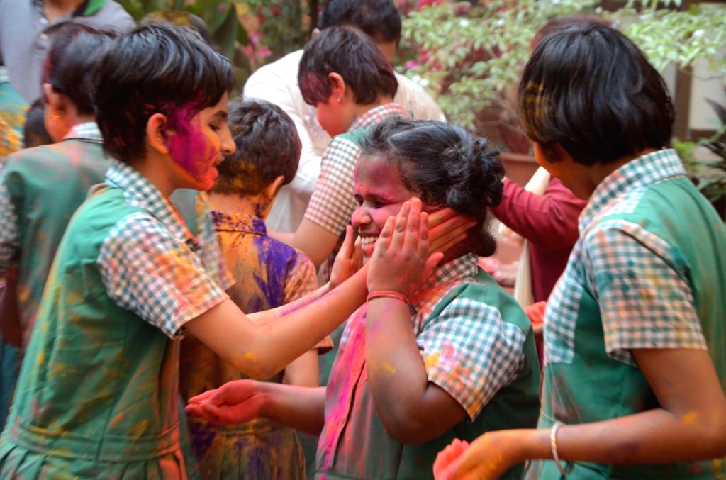 Blind students play with colors at their school on the eve of Holi in ...
