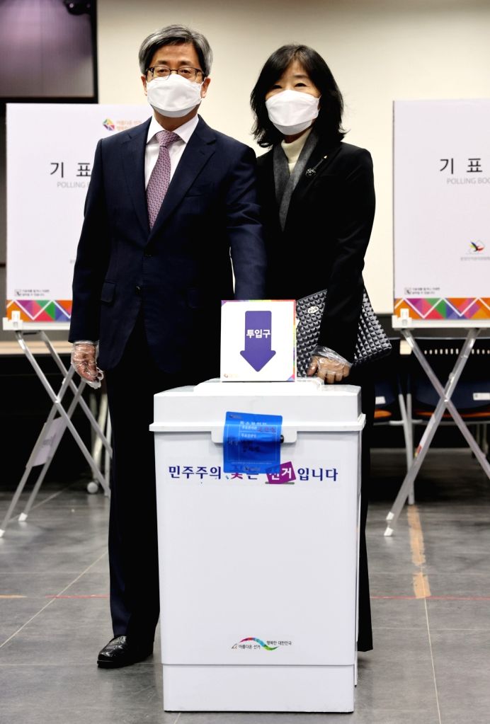 :Seoul:Chief Justice Kim Myeong-su (L) votes with his wife, Lee Hye-joo ...