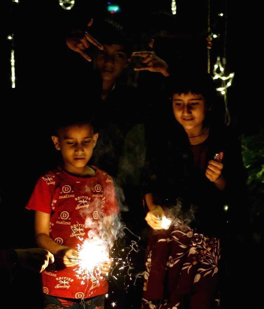 Children burst firecrackers during Diwali celebrations in New Delhi