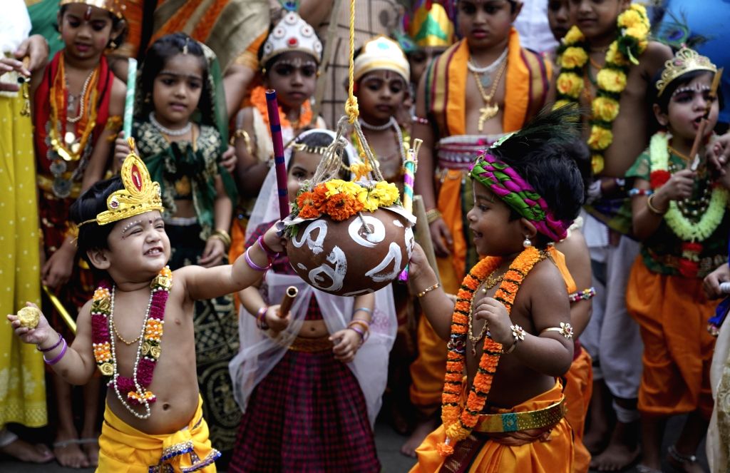 Children dressed up as Lord Krishna and others break the pot