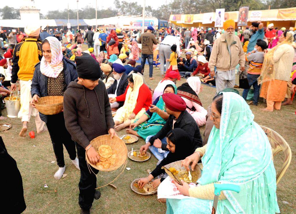 Children serve food during a 'langar' organised on the birth ...