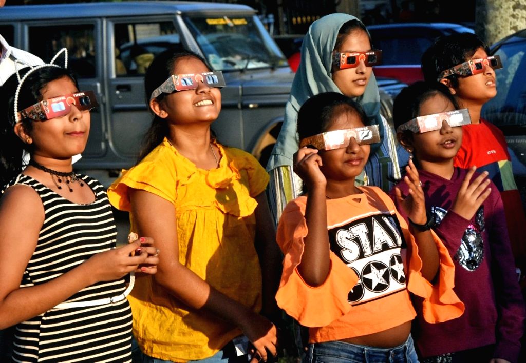 Children wearing eclipse viewers try to watch the partial solar eclipse