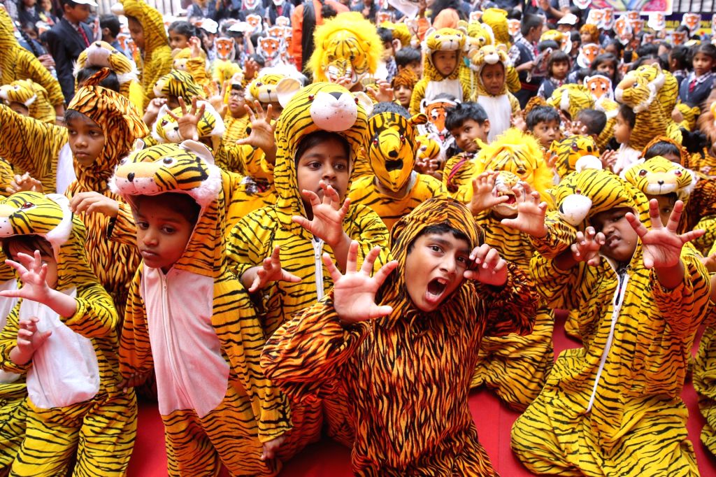 Children wearing tiger costumes participate in an awareness programme ...