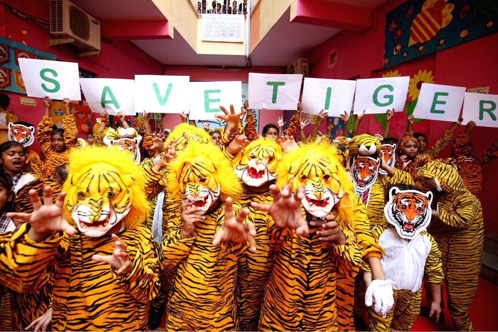 Children wearing tiger costumes participate in an awareness programme ...